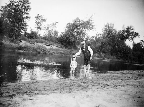 Man and Child Wading in Water | Photograph | Wisconsin Historical Society