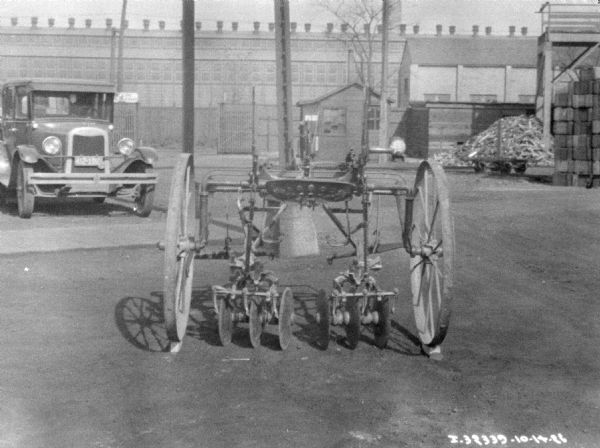 Cultivator Parked near Factory | Photograph | Wisconsin Historical Society
