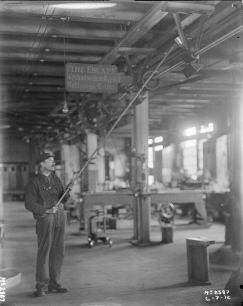 Man Oiling Overhead Gears | Photograph | Wisconsin Historical Society