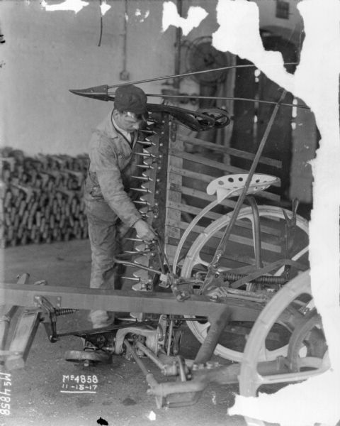 Man Making Adjustments on Mower | Photograph | Wisconsin Historical Society