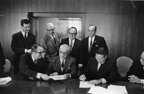 Men Signing Paperwork | Photograph | Wisconsin Historical Society